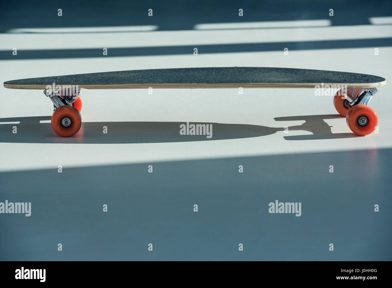 skateboard with orange wheels and shadows on white floor Stock Photo ...