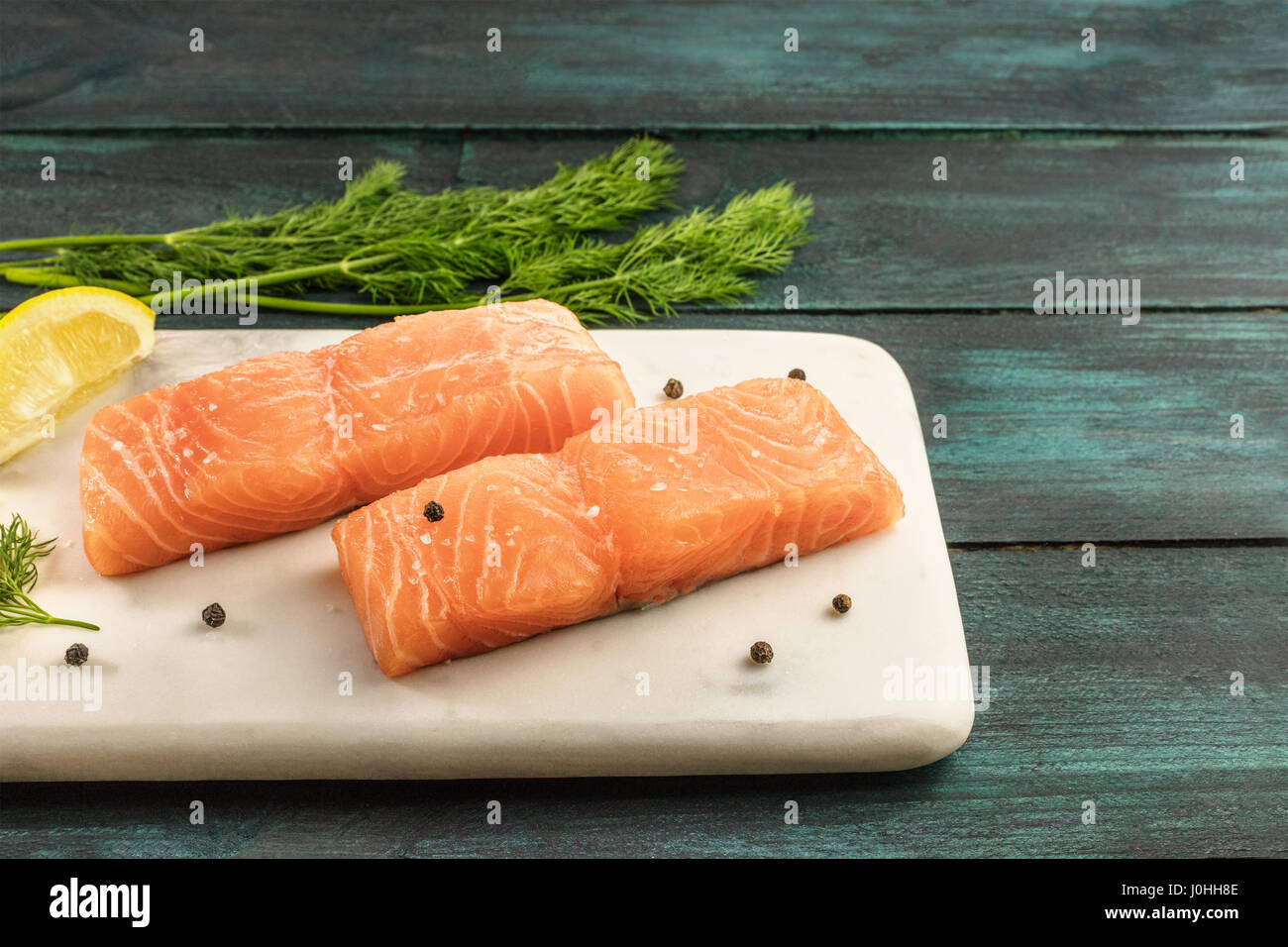 Two slices of salmon on dark background with copyspace Stock Photo - Alamy