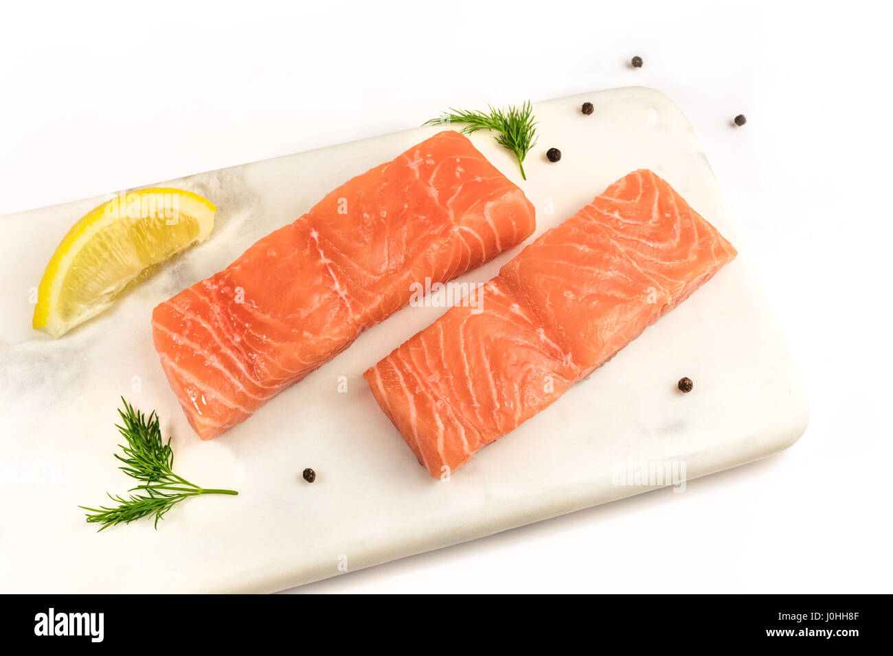 Two slices of salmon on white marble cutting board Stock Photo - Alamy