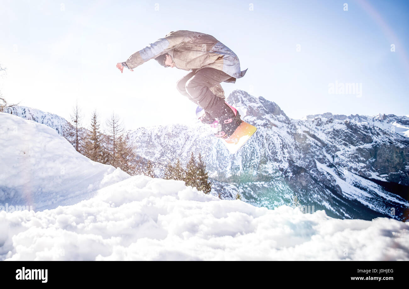 Snoboarder performing tricks on the snow Stock Photo - Alamy