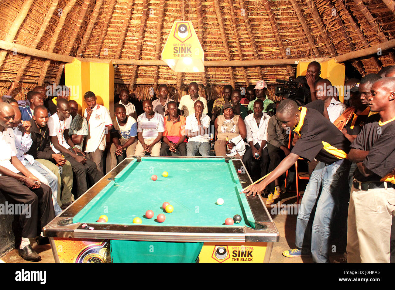 Pool fans following a local game inside a hut in Arua town in north ...