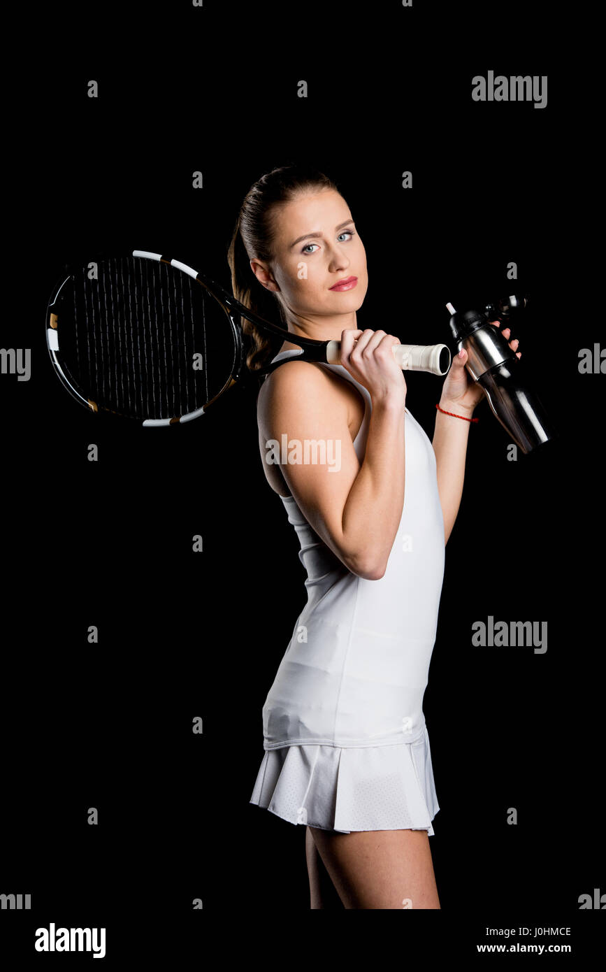Attractive female tennis player holding sport bottle and tennis racquet ...