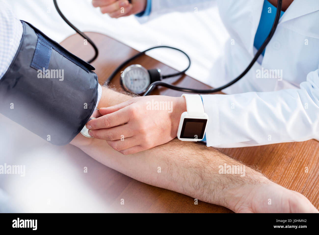 Close-up view of doctor in smartwatch measuring pressure of patient ...