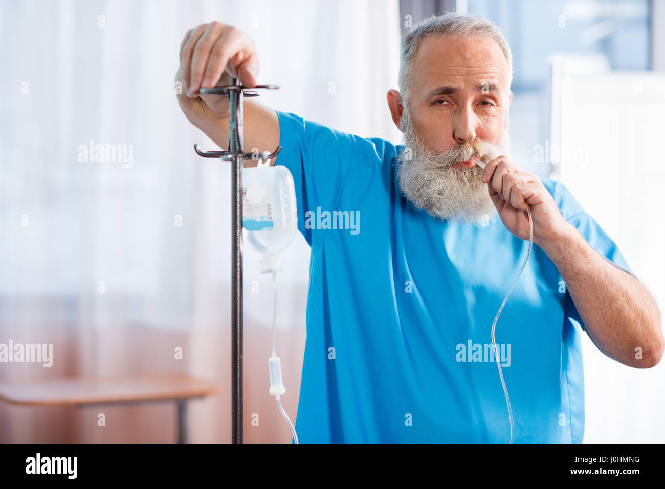 Senior bearded man blowing in drop counter in hospital Stock Photo - Alamy