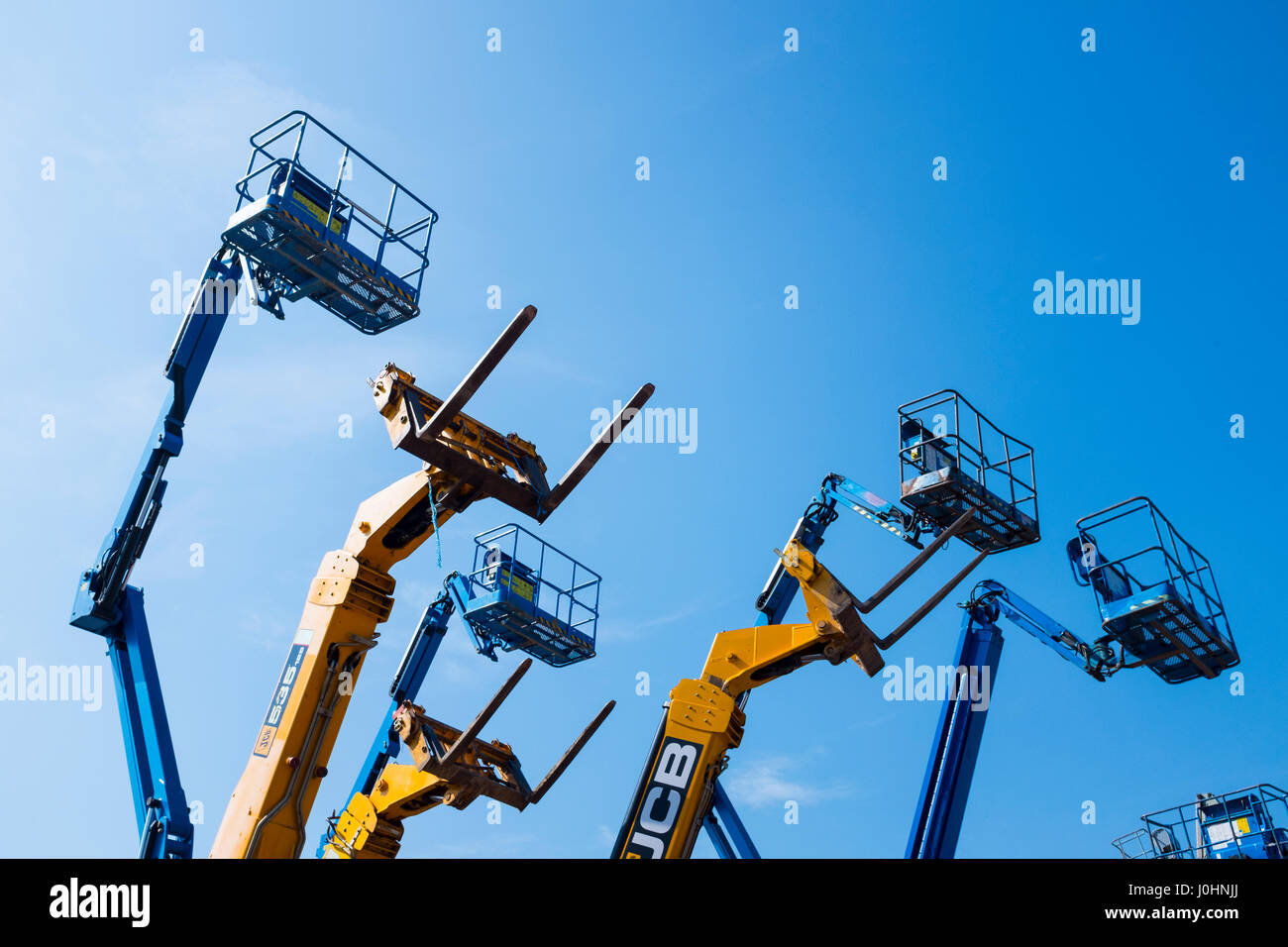 Cherry pickers in upright position with blue sky Stock Photo - Alamy