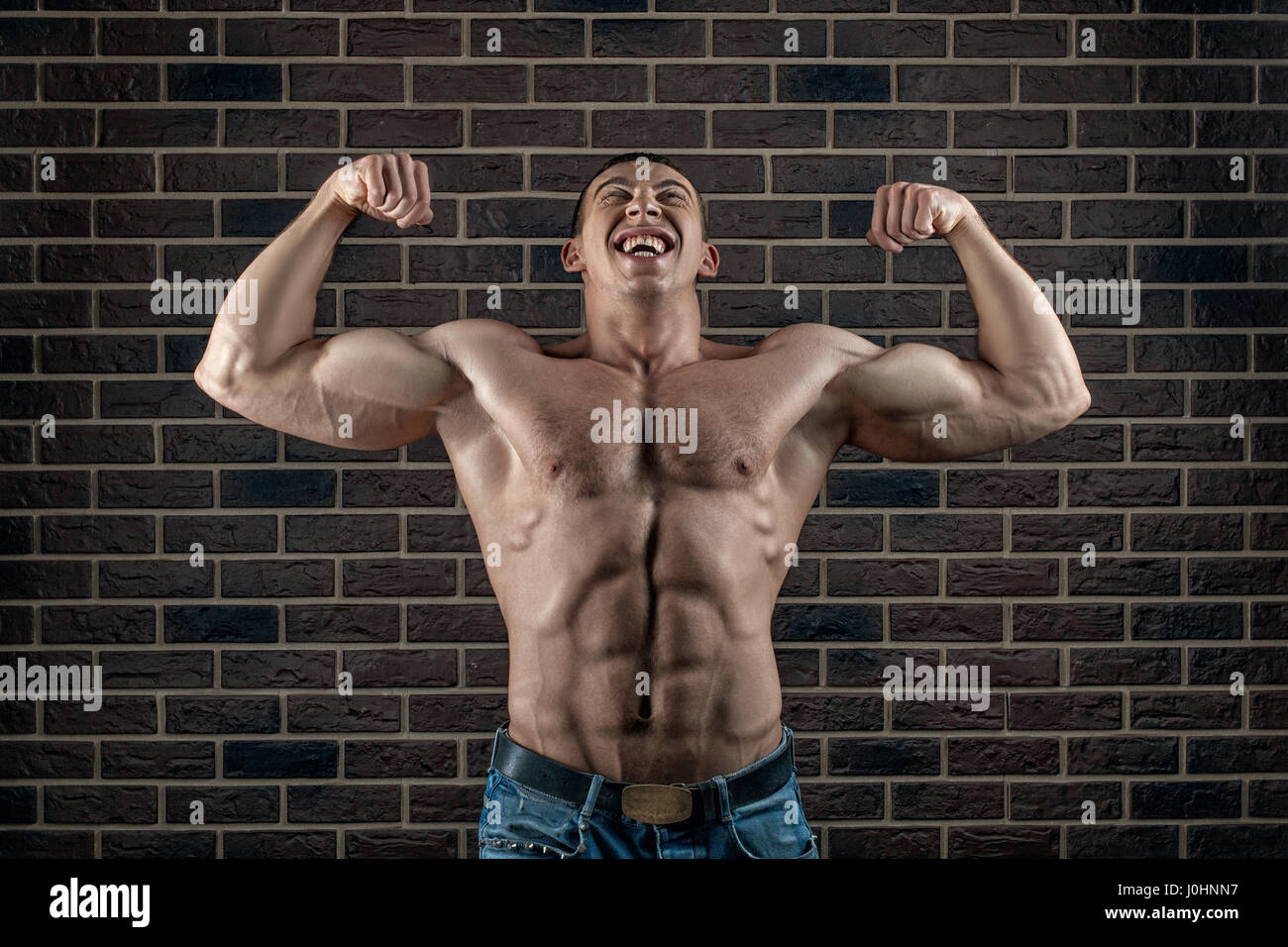 bodybuilder man raised his hands and shouts Stock Photo - Alamy