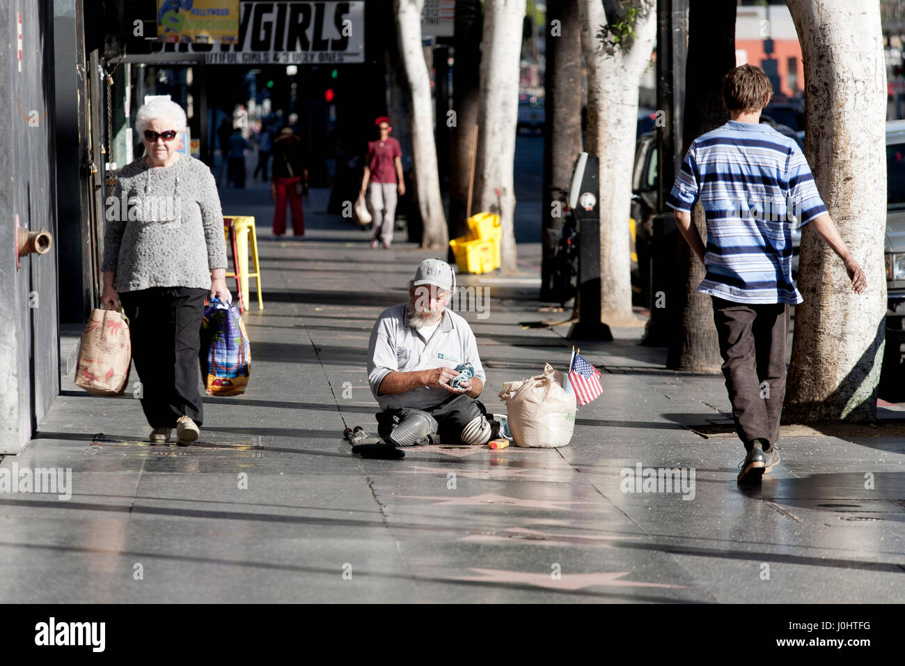 A homeless man burnishes the stars on the Hollywood walk of Fame Stock ...