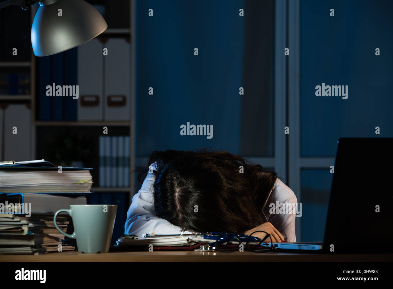 Overworked medical staff take rest sleeping on desk of clinic room ...