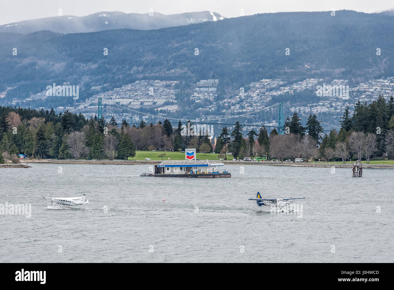 Two seaplanes (float planes) pass each other in front of the floating ...
