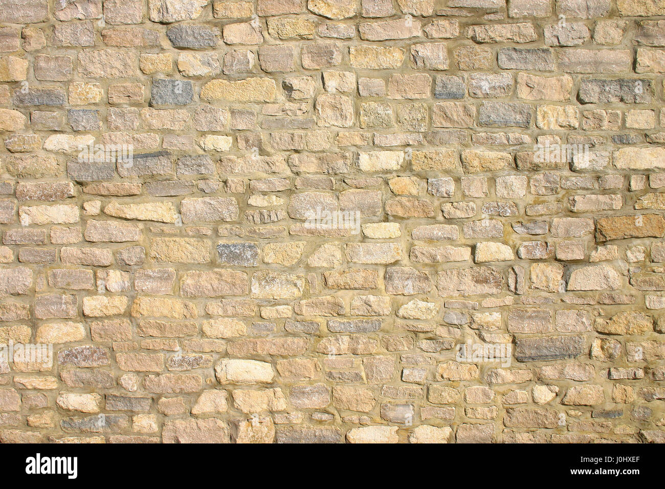 A yellow colored stone wall construction Stock Photo - Alamy