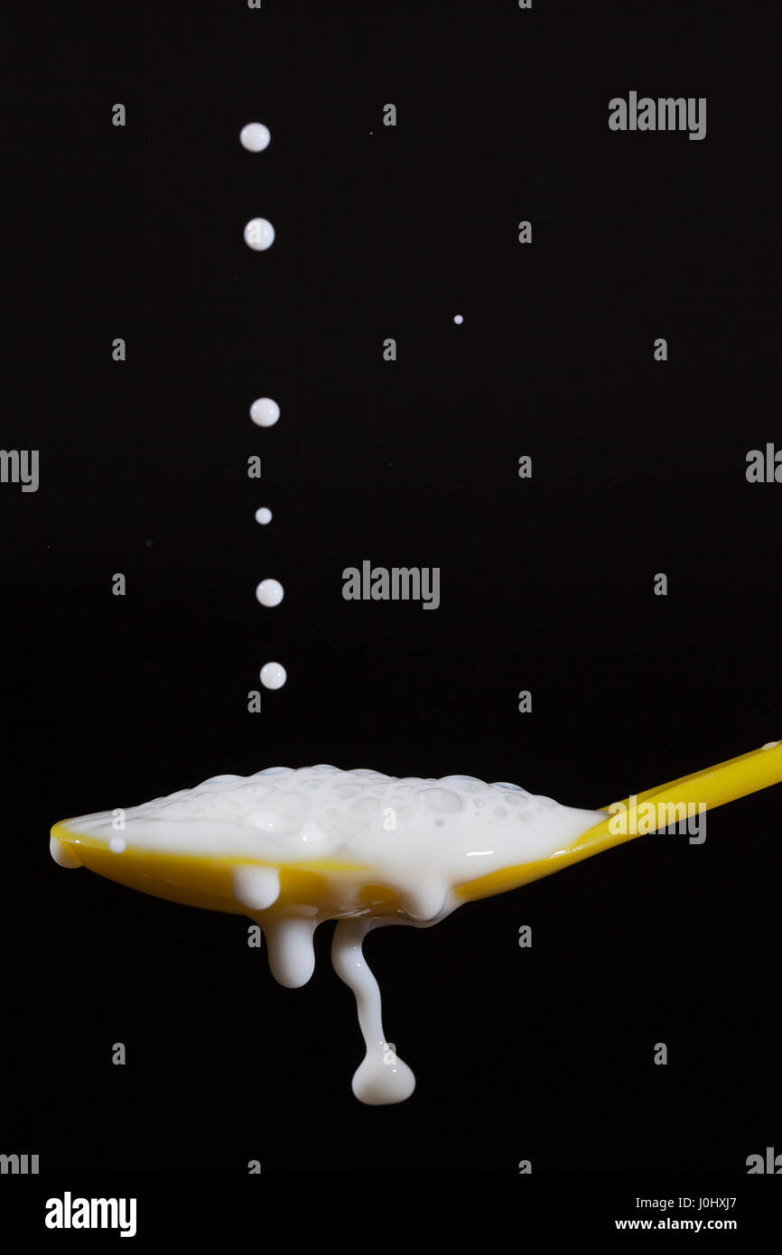White milk and yellow spoon Stock Photo - Alamy
