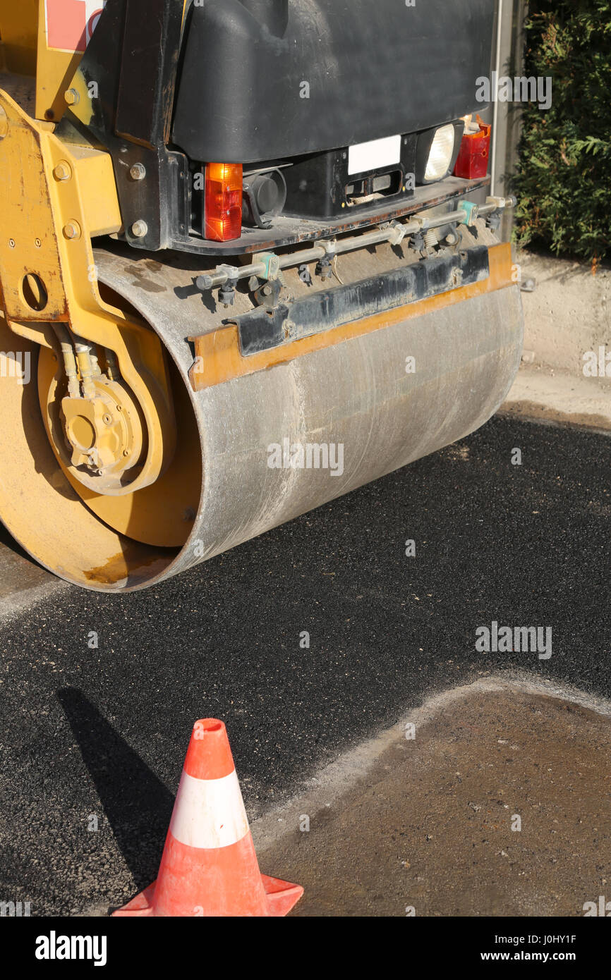 detail of an heavy road roller on the road and a traffic cone Stock ...