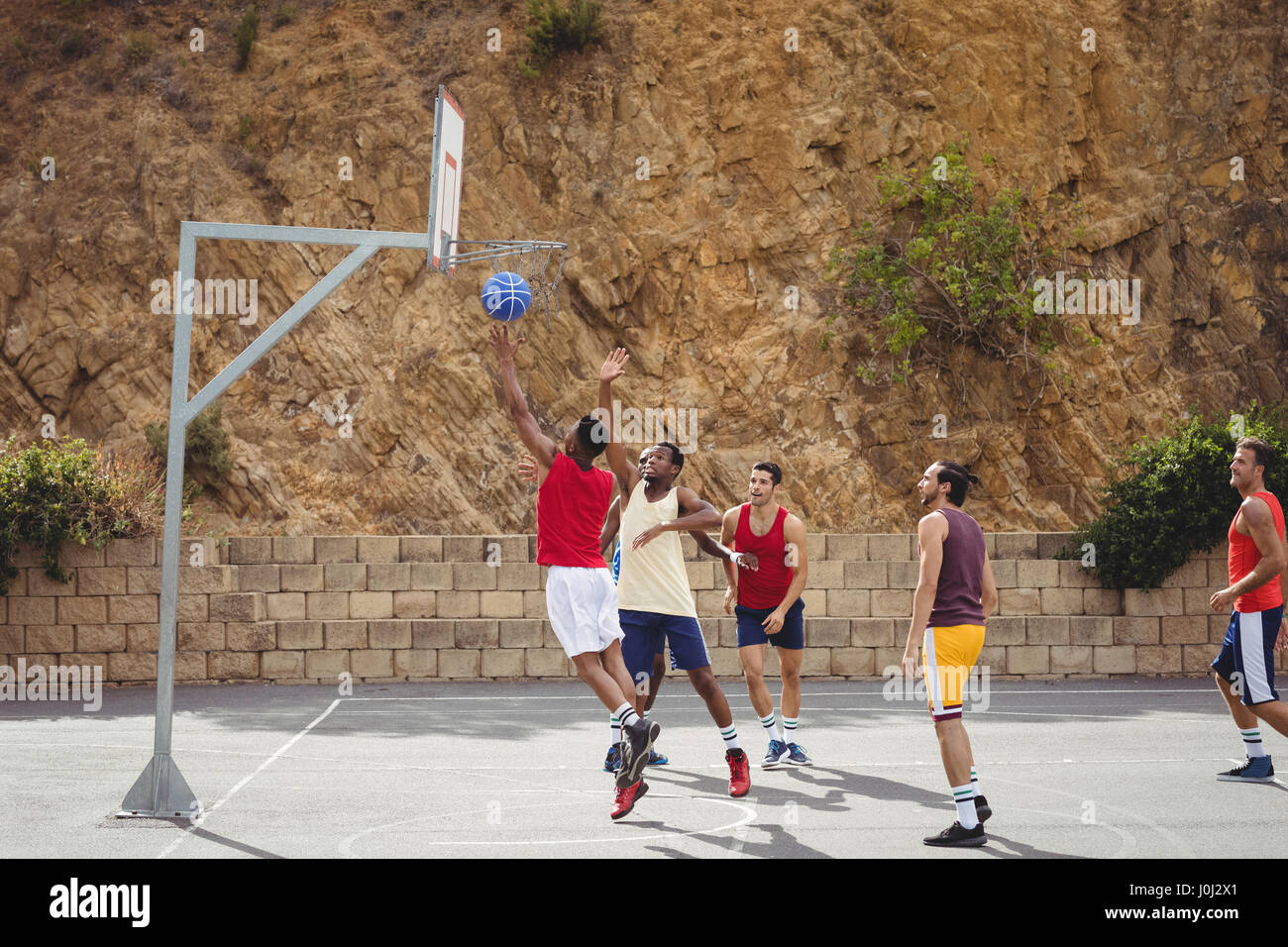 Basketball players playing basketball in the court outdoors Stock Photo ...