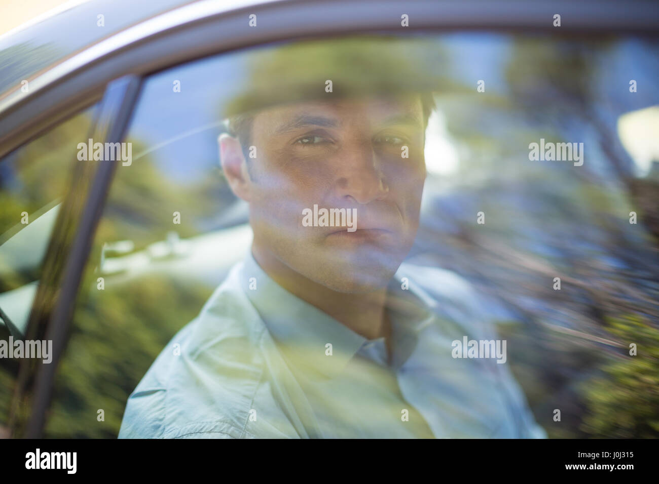 Serious man seen through car window Stock Photo - Alamy
