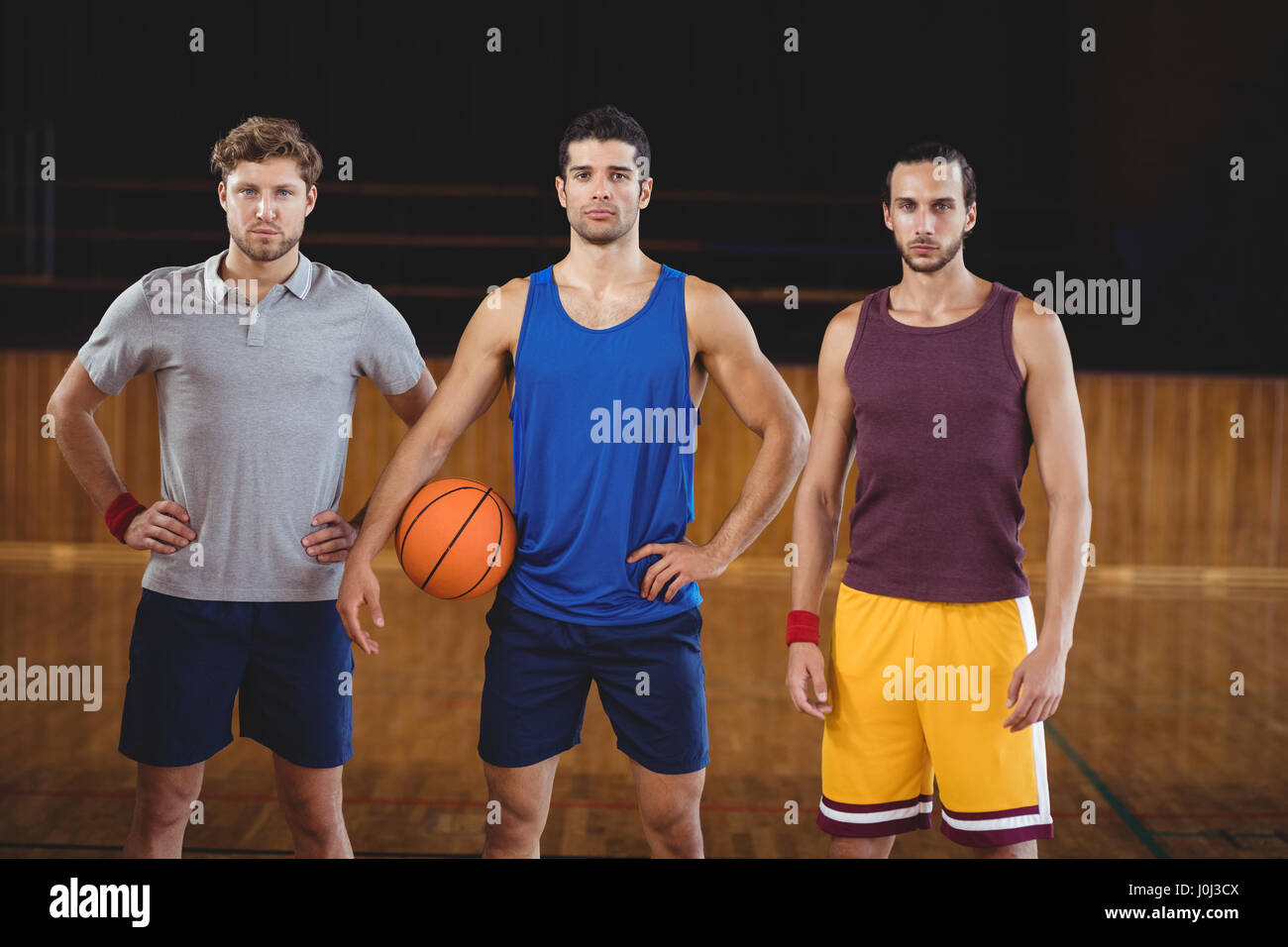 Portrait of male basketball players standing in basketball court Stock ...