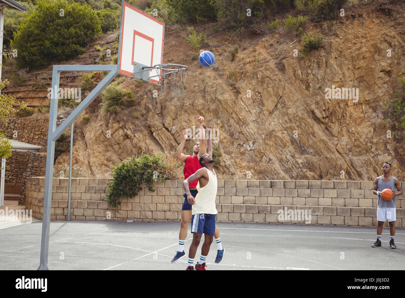 Basketball players playing practicing in basketball court outdoors ...