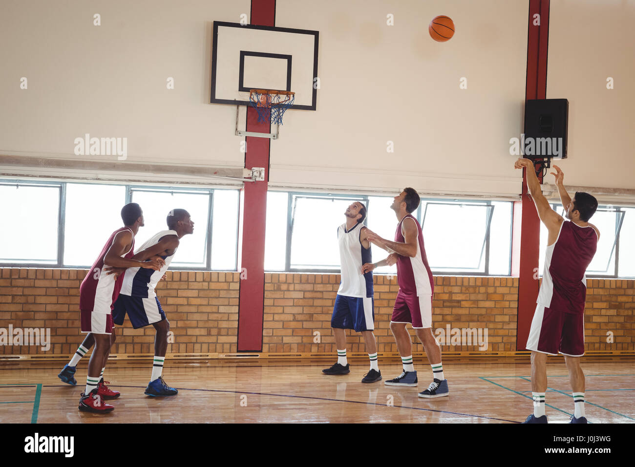 Basketball player taking a penalty shot in basketball court Stock Photo ...