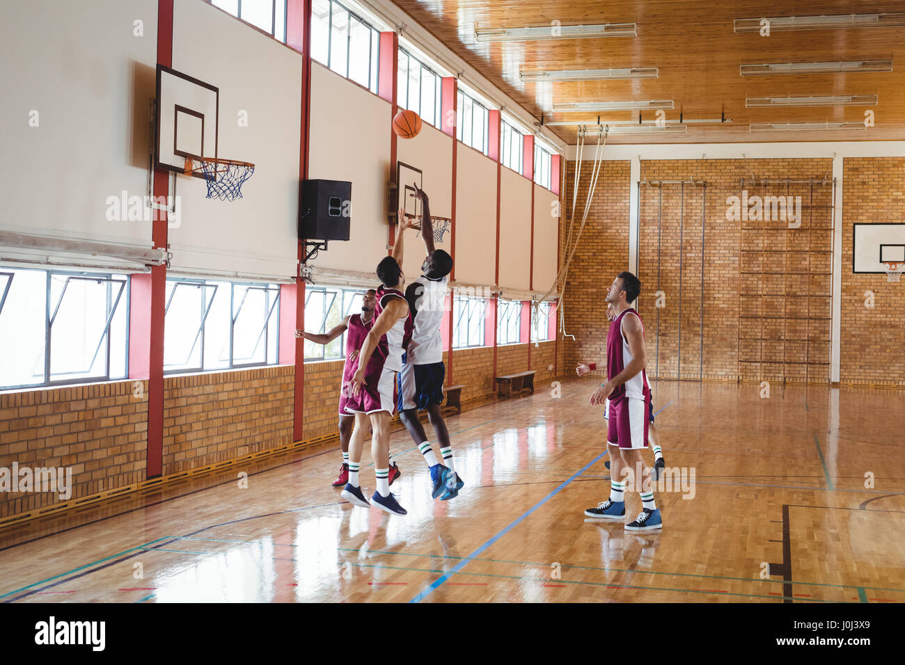 Basketball players playing basketball in the court indoors Stock Photo ...