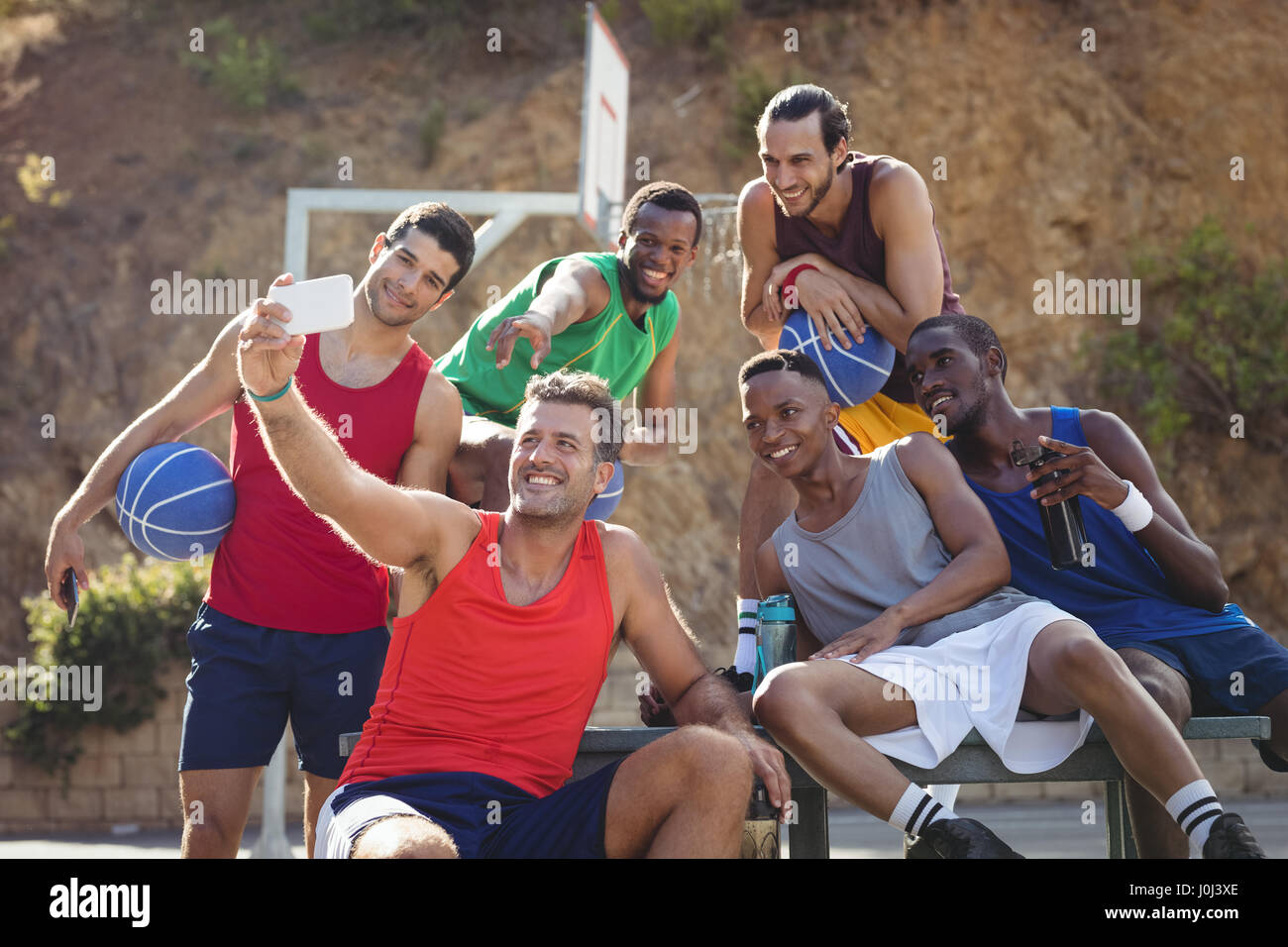 Basketball players taking a selfie in basketball court outdoors Stock ...