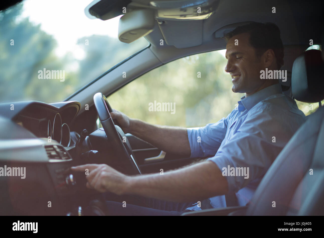 Side view of smiling man driving car Stock Photo - Alamy