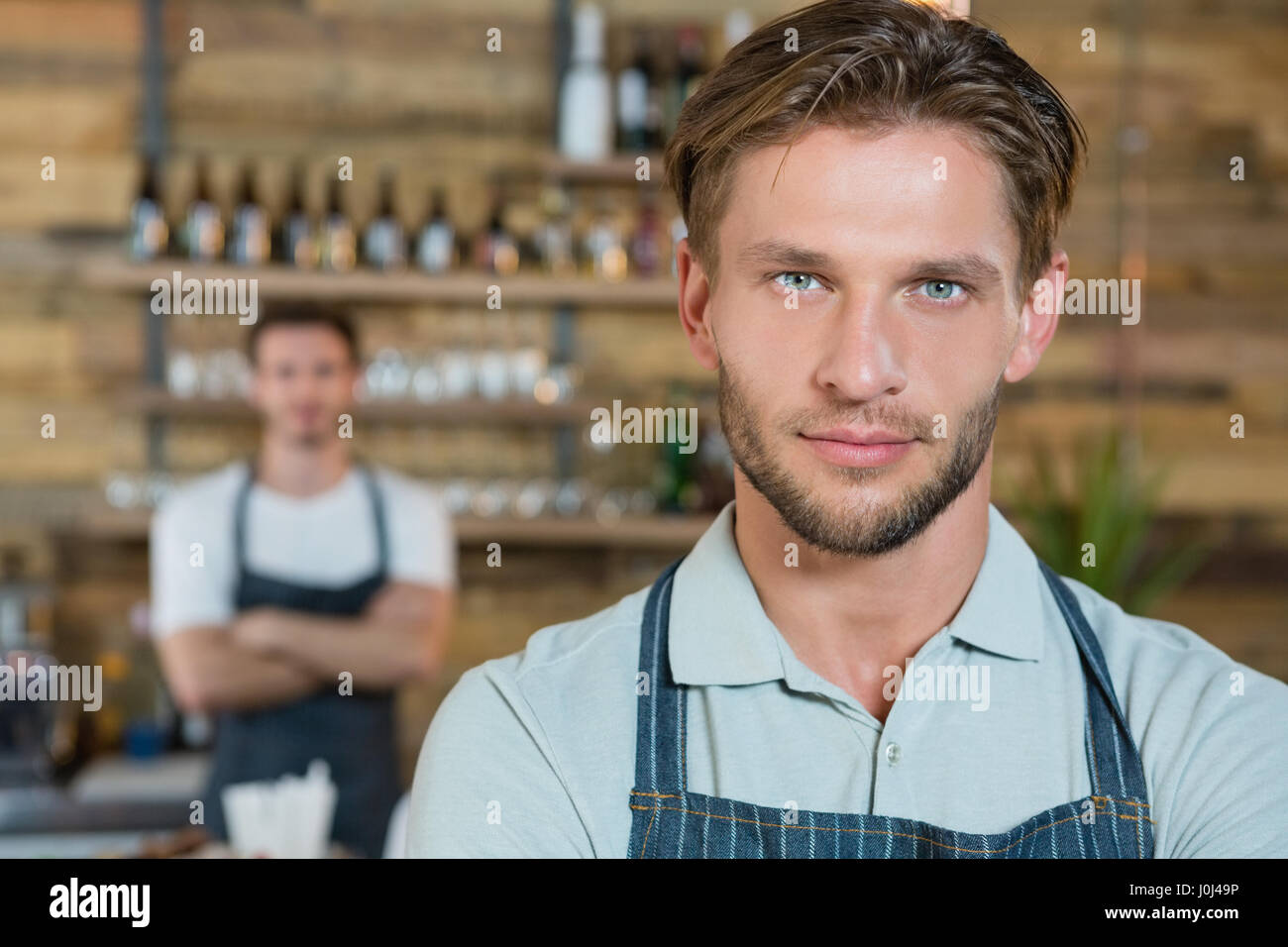 Portrait of waiter standing behind the counter in cafe Stock Photo - Alamy