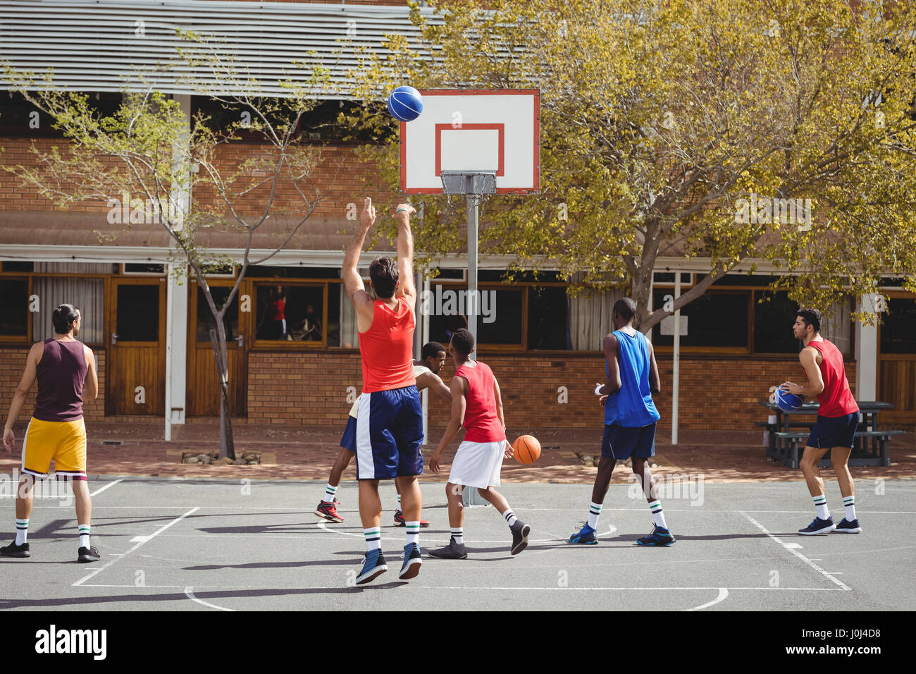 Basketball players practicing in basketball court outdoors Stock Photo ...