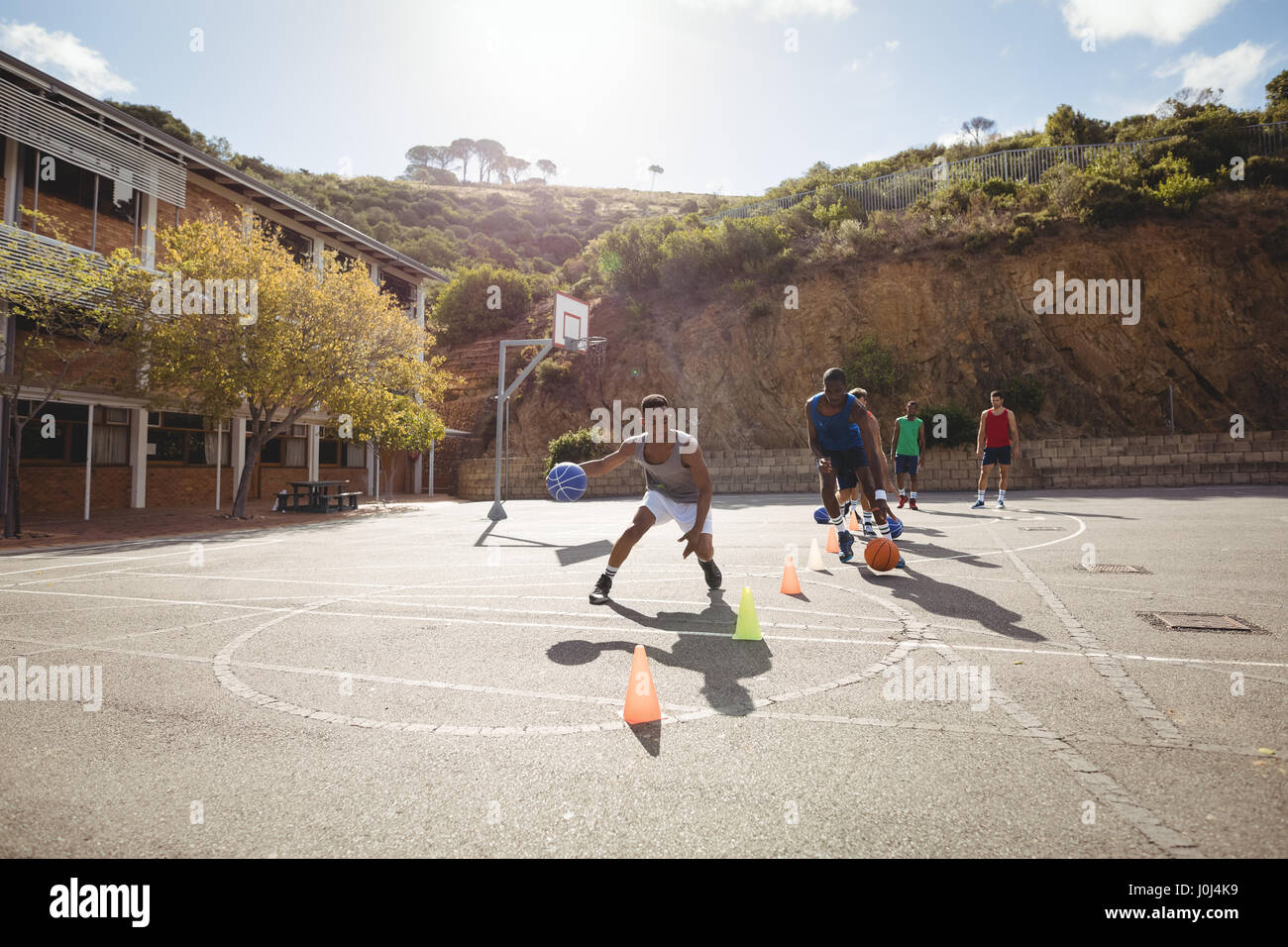 Basketball players practicing dribbling drill in basketball court ...