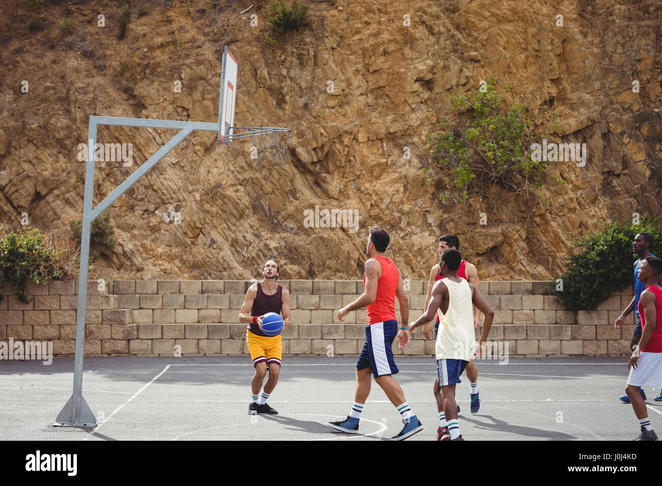 Basketball players playing basketball in the court outdoors Stock Photo ...