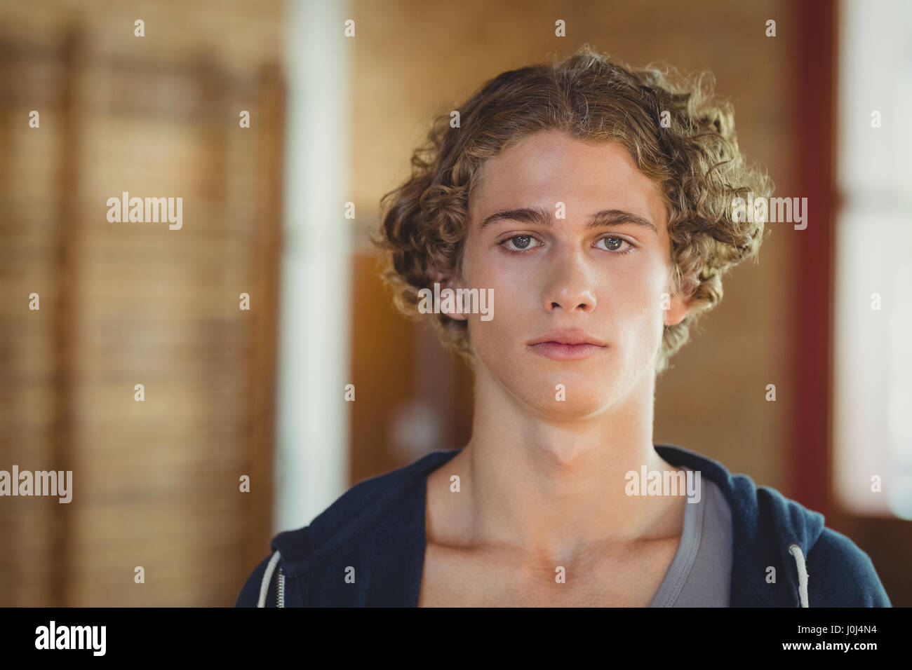 Portrait of determined high school boy standing in the sports court ...