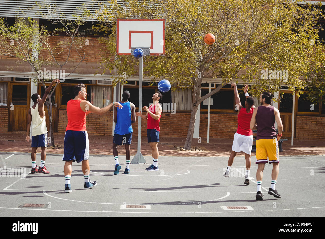 Basketball players practicing in basketball court outdoors Stock Photo ...