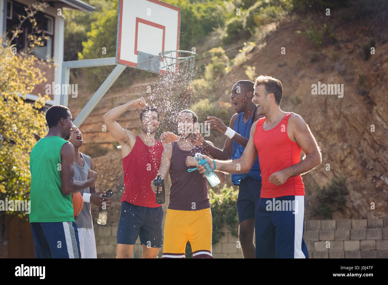 Basketball players celebrating by splashing water on each other in ...