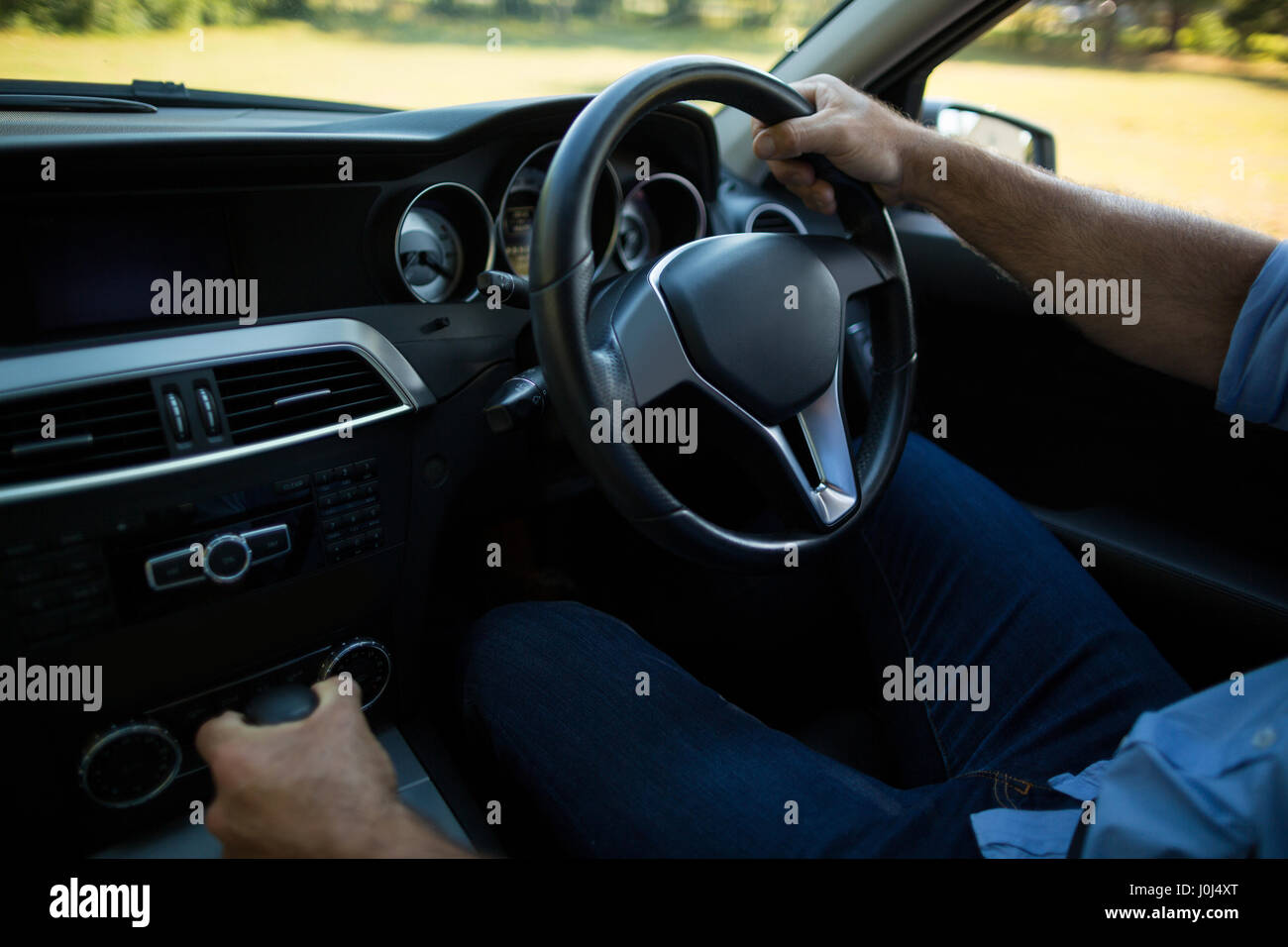 Mid section of man driving car Stock Photo - Alamy