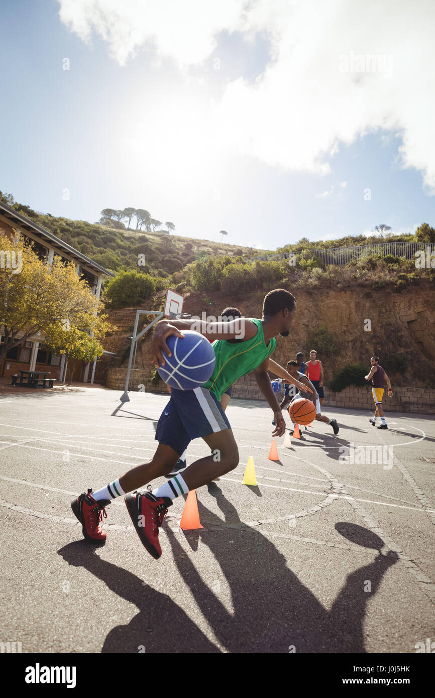 Basketball players practicing dribbling drill in basketball court ...