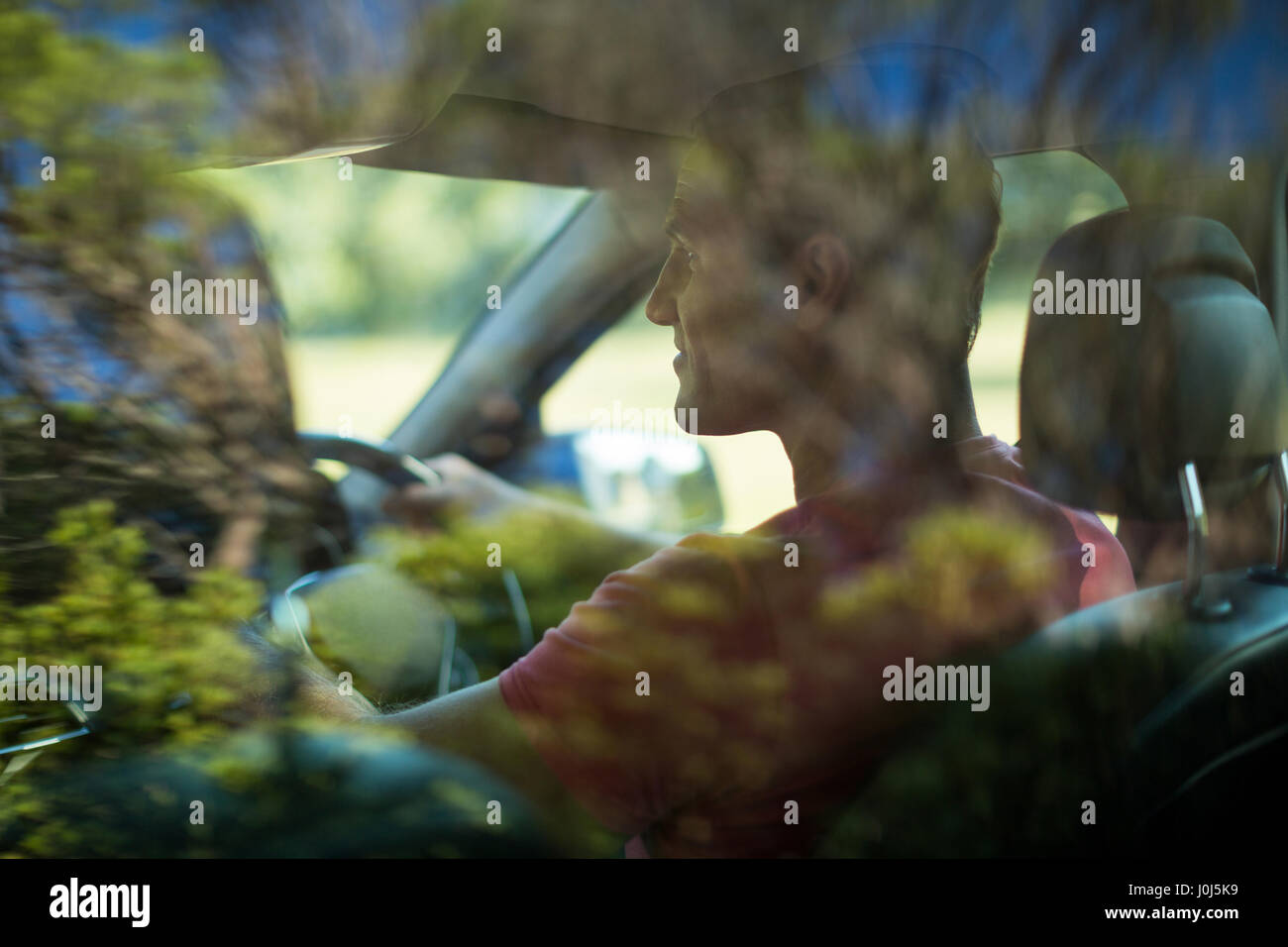 Rear view of man seen through car windshield Stock Photo - Alamy