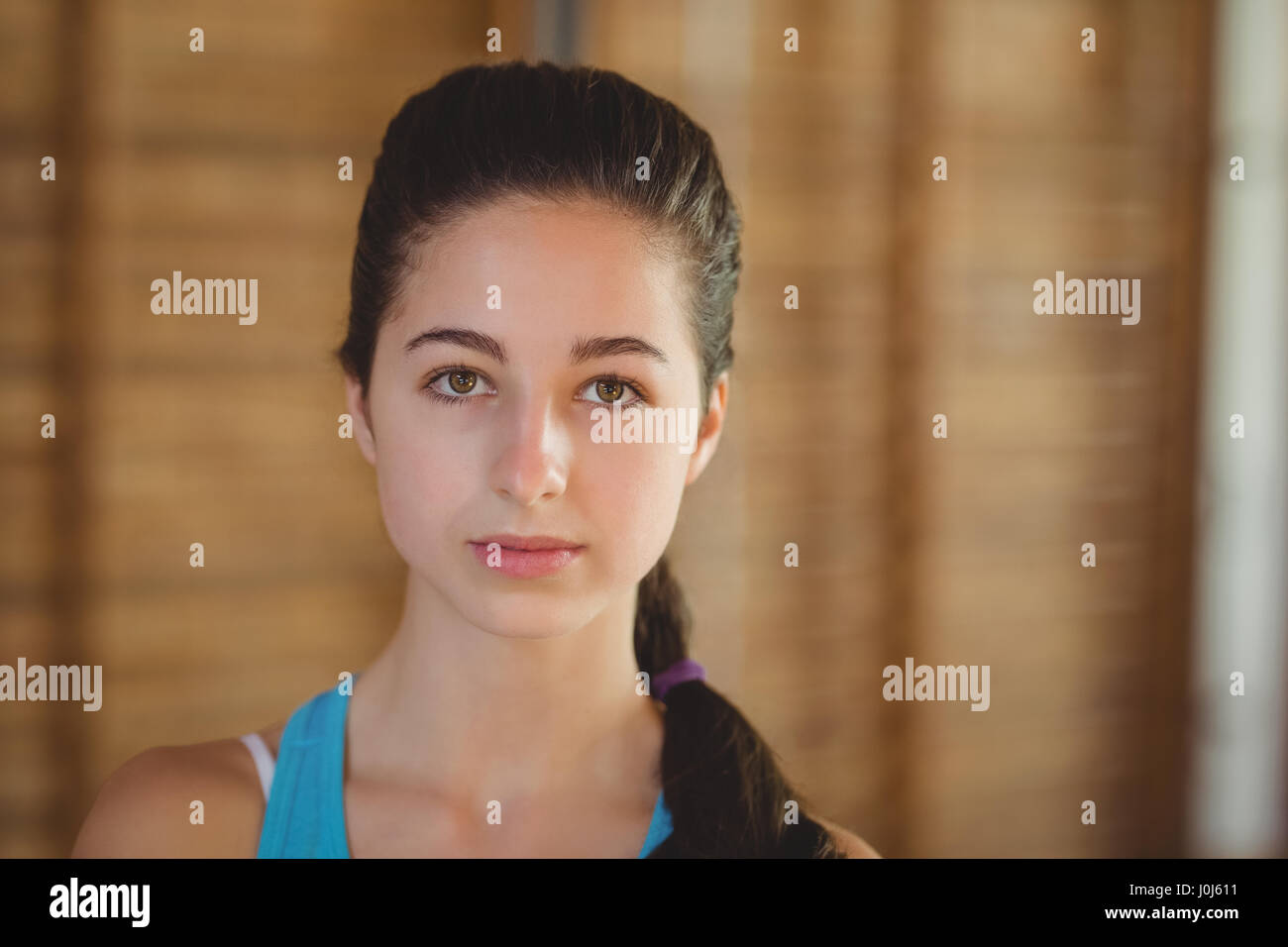 Portrait of determined high school girl standing in the sports court ...