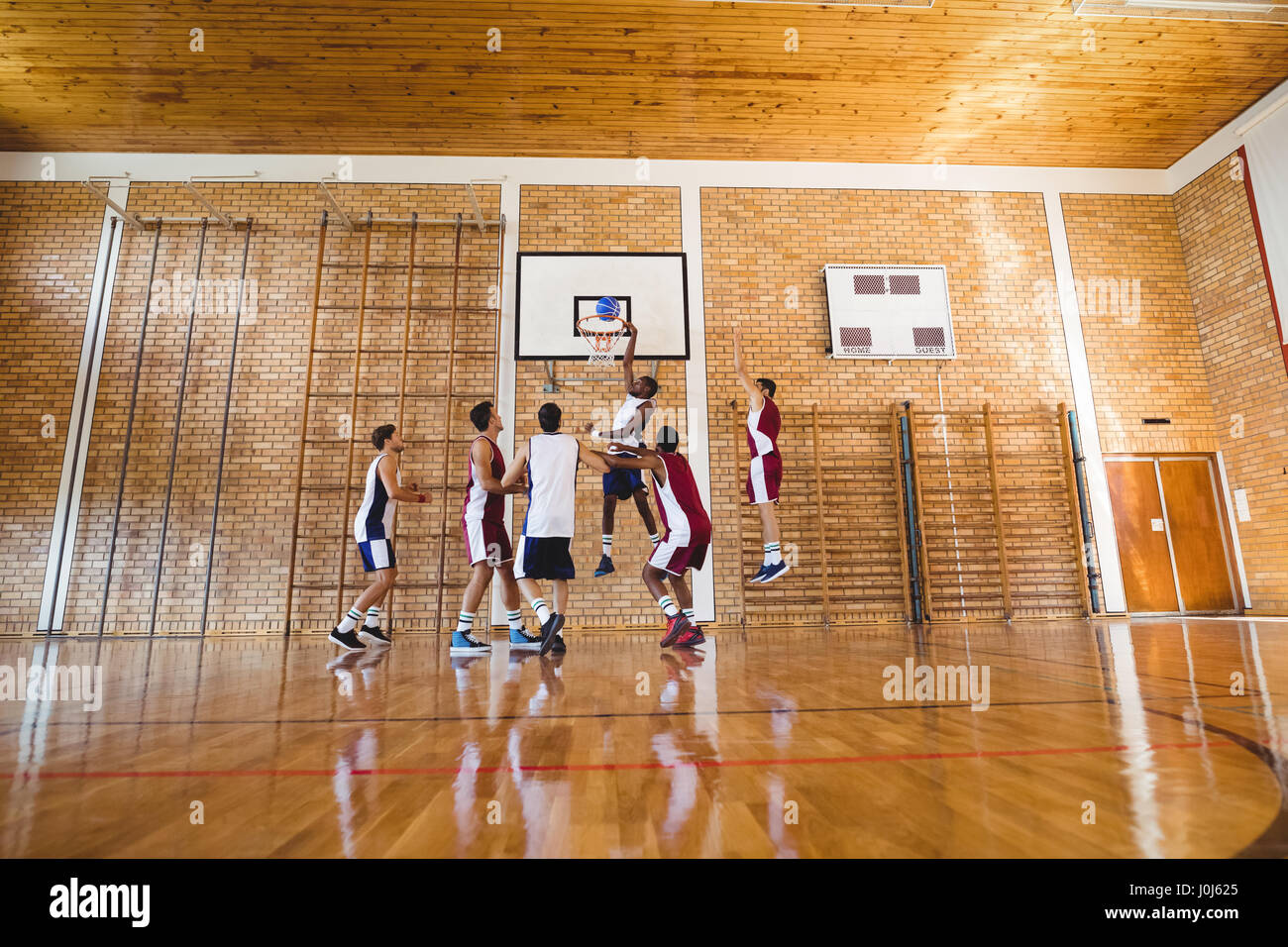 Player scoring a goal while playing basketball in the court Stock Photo ...