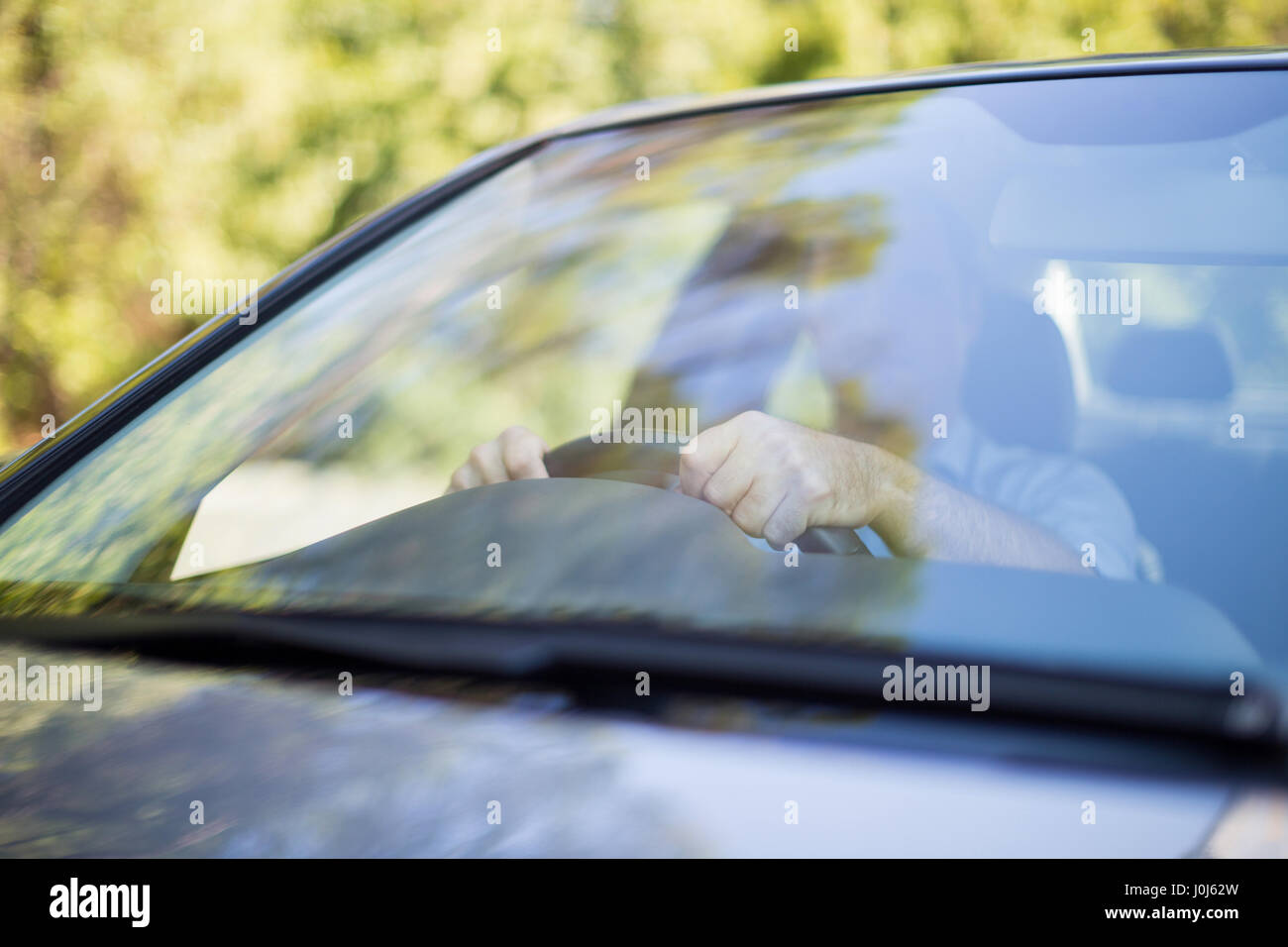 Man driving car seen through windshield Stock Photo - Alamy