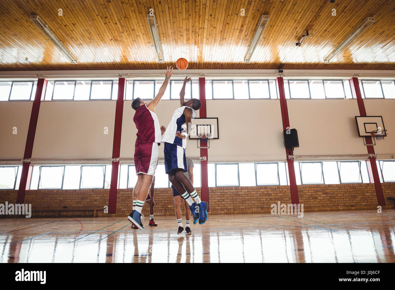 Basketball players playing basketball in the court indoors Stock Photo ...