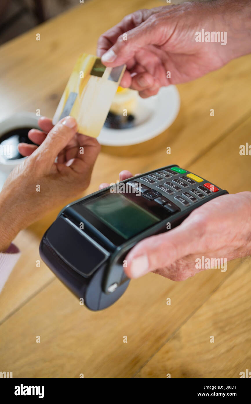 Senior woman making payment through credit card in cafÃƒÂ© Stock Photo ...