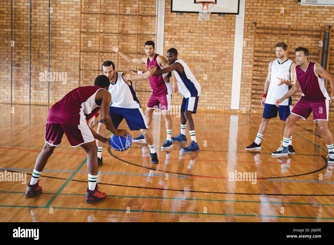 Determined basketball players playing in the court Stock Photo - Alamy