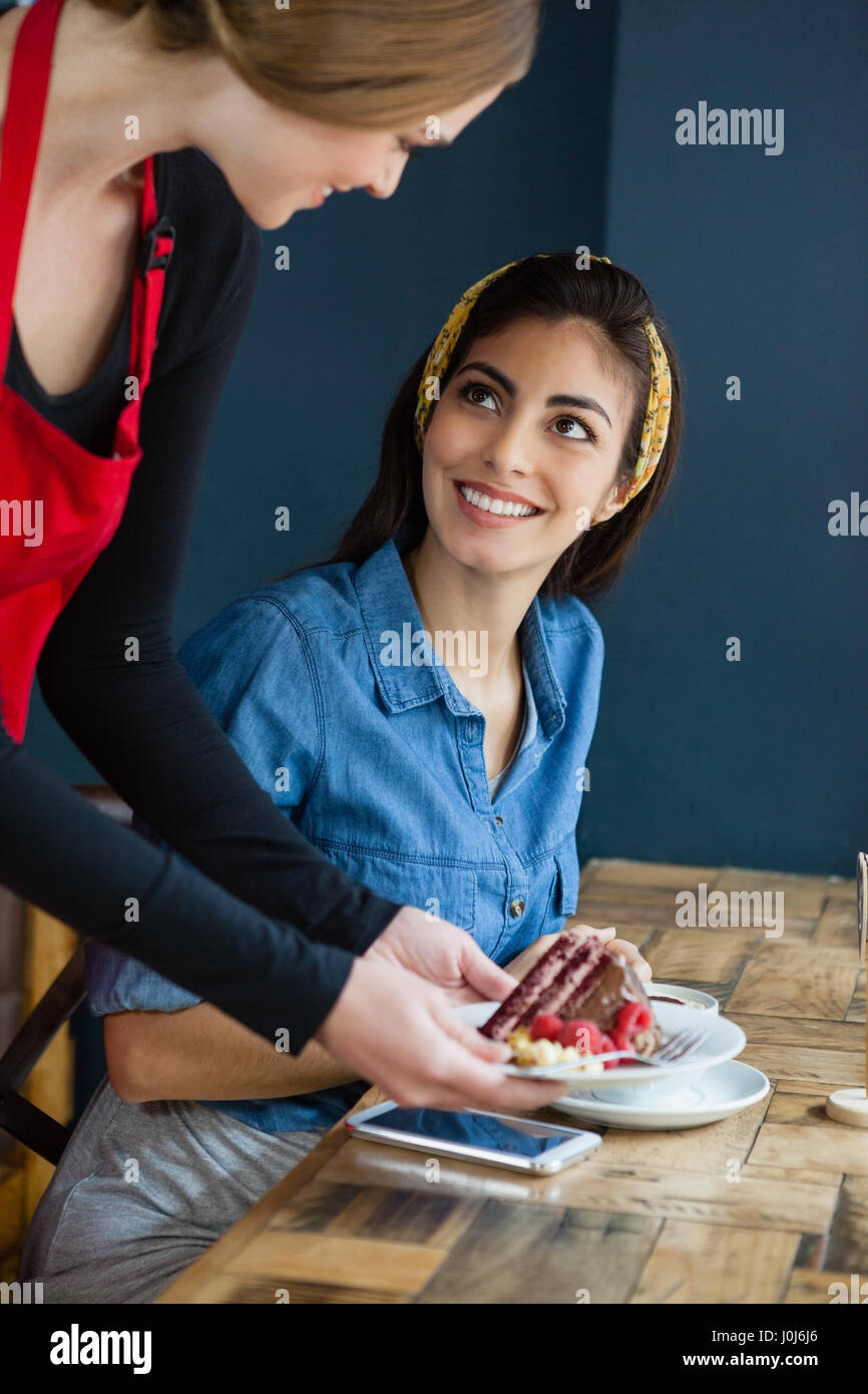 Smiling owner serving sweet food to customer at cafe shop Stock Photo ...