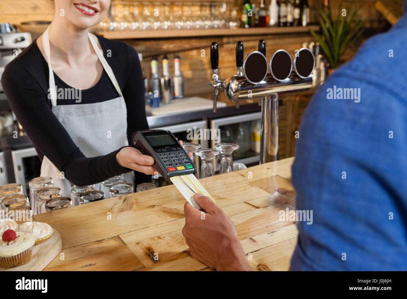 Man making payment on credit card reader machine at cafe shop Stock ...
