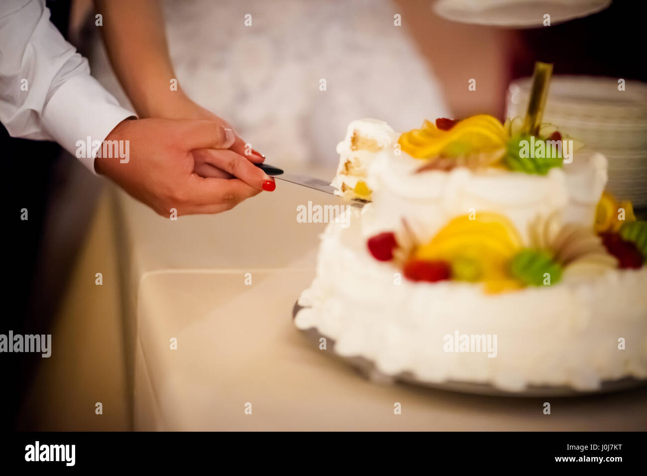 Beautiful wedding cake detail. Traditional first slice cutting by Bride ...