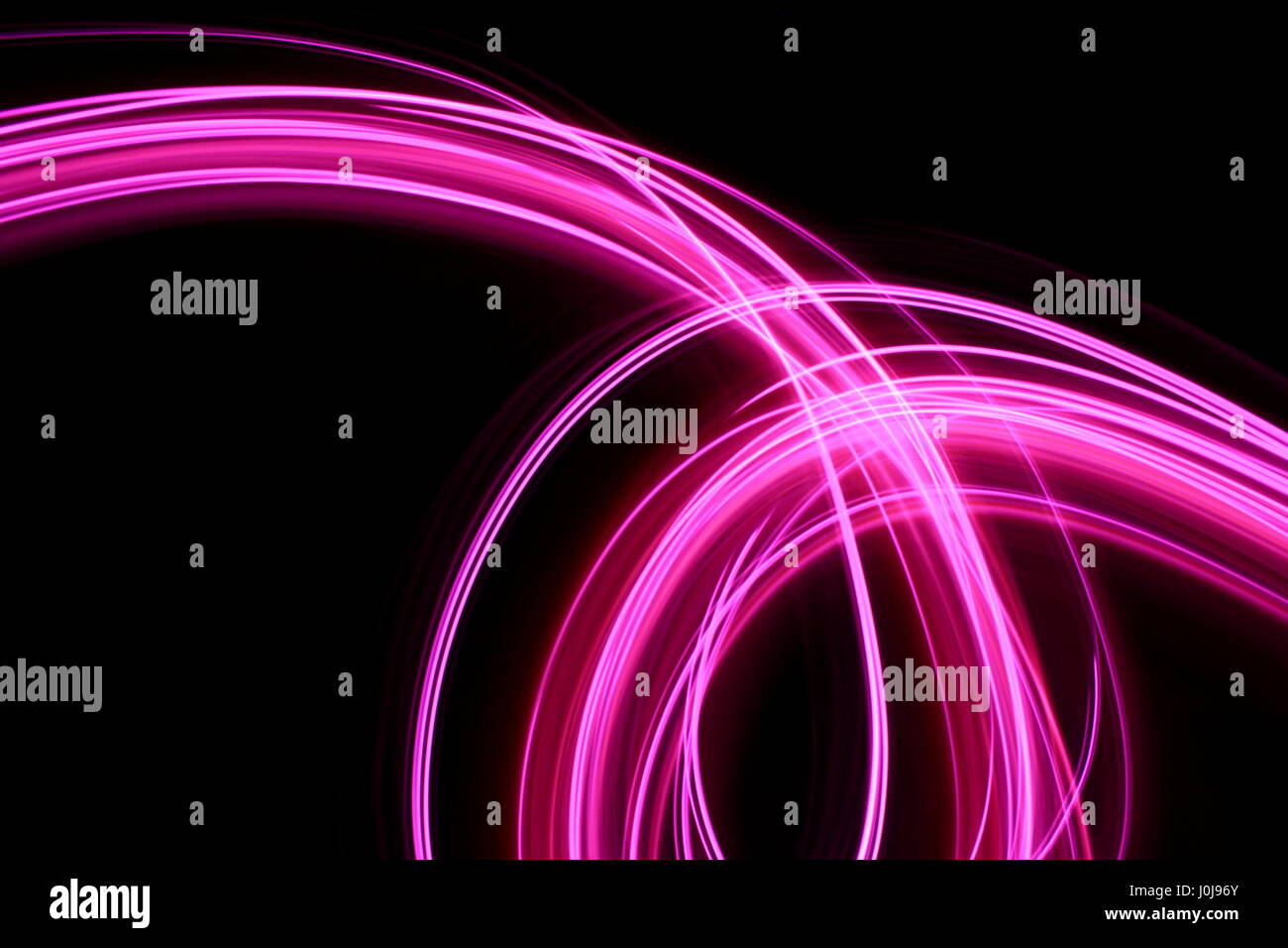 Long exposure photograph of vibrant neon pink colour in an abstract ...