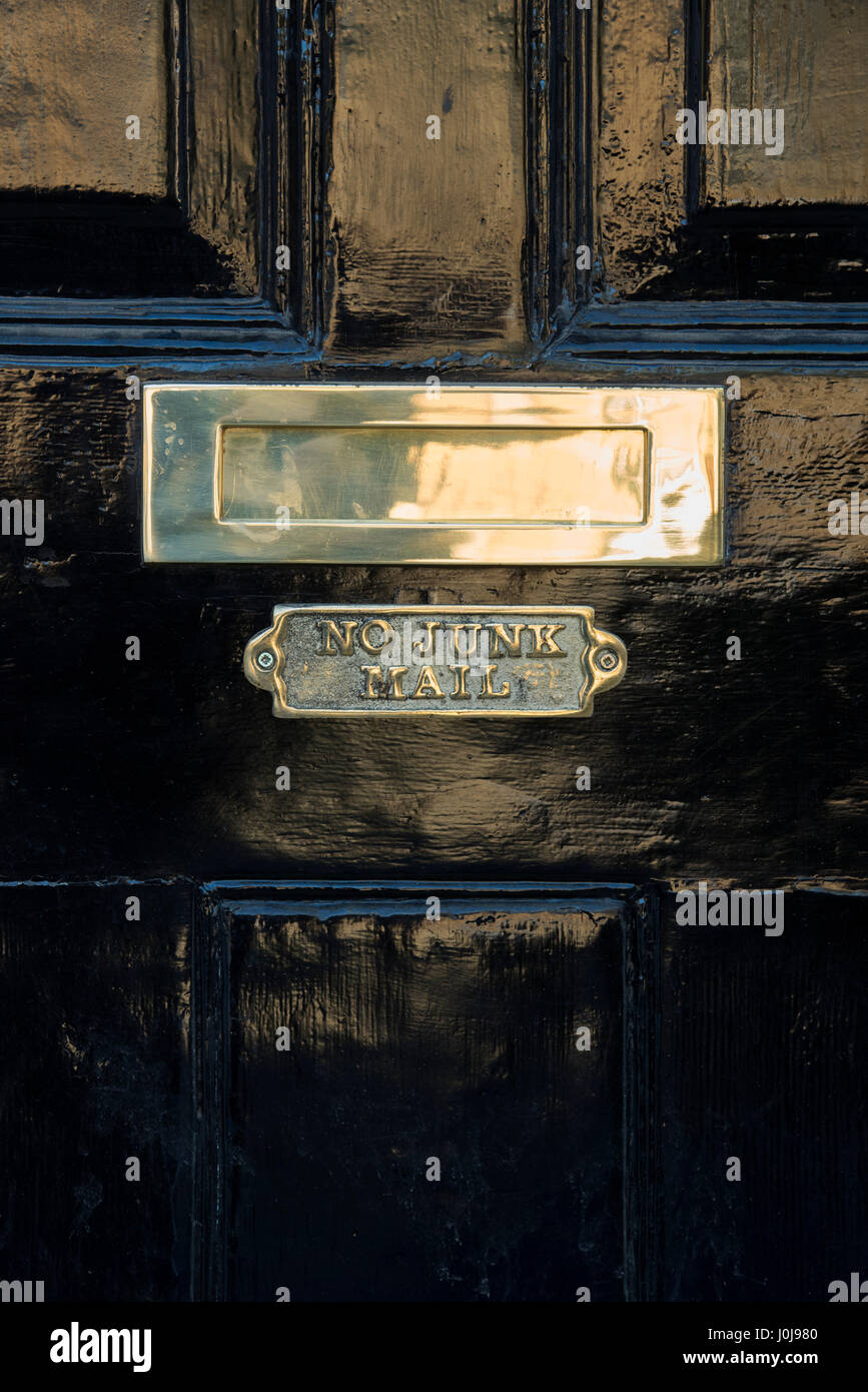 No Junk Mail brass plaque under a brass letterbox on a black wooden ...