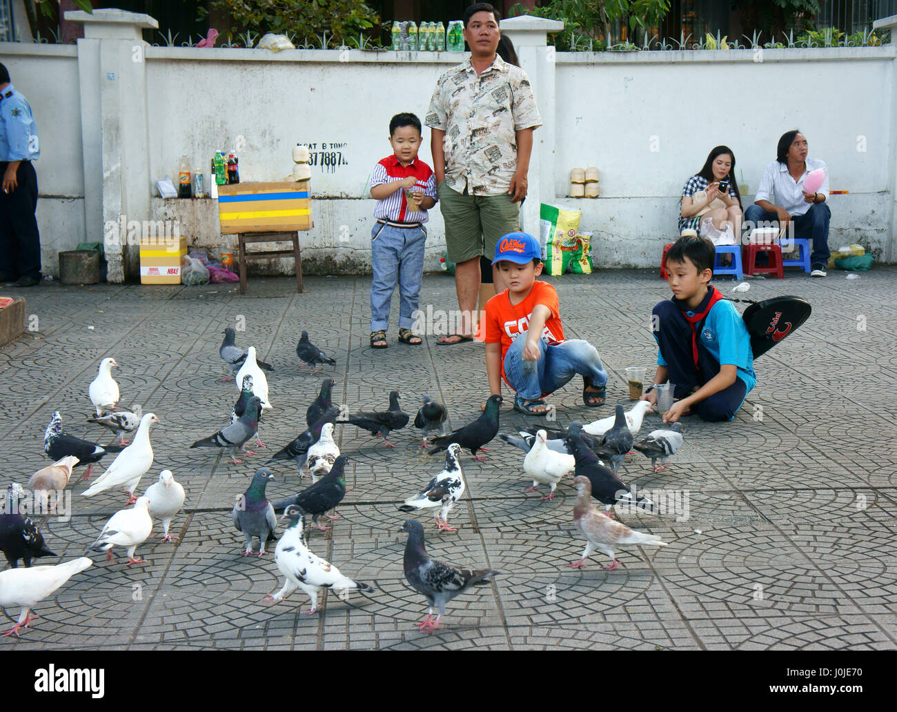 HO CHI MINH CITY, VIET NAM- DEC 24: Asian kid feeding bird with ...