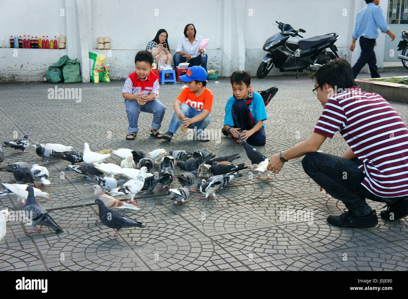 HO CHI MINH CITY, VIET NAM- DEC 24: Asian kid feeding bird with ...