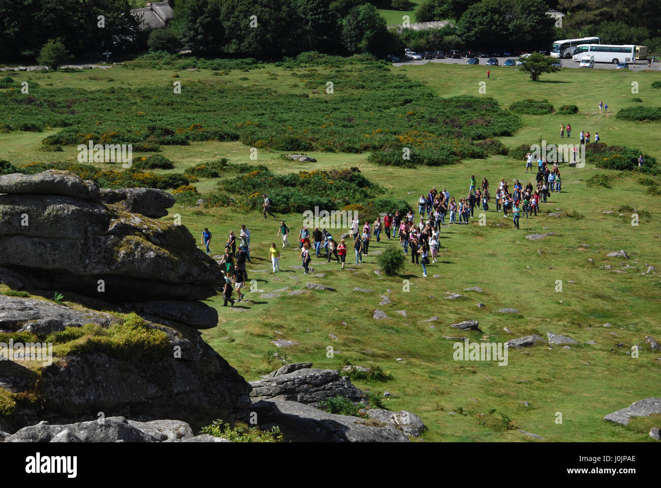 busload of people walking towards Hound Tor Dartmoor National park, UK ...