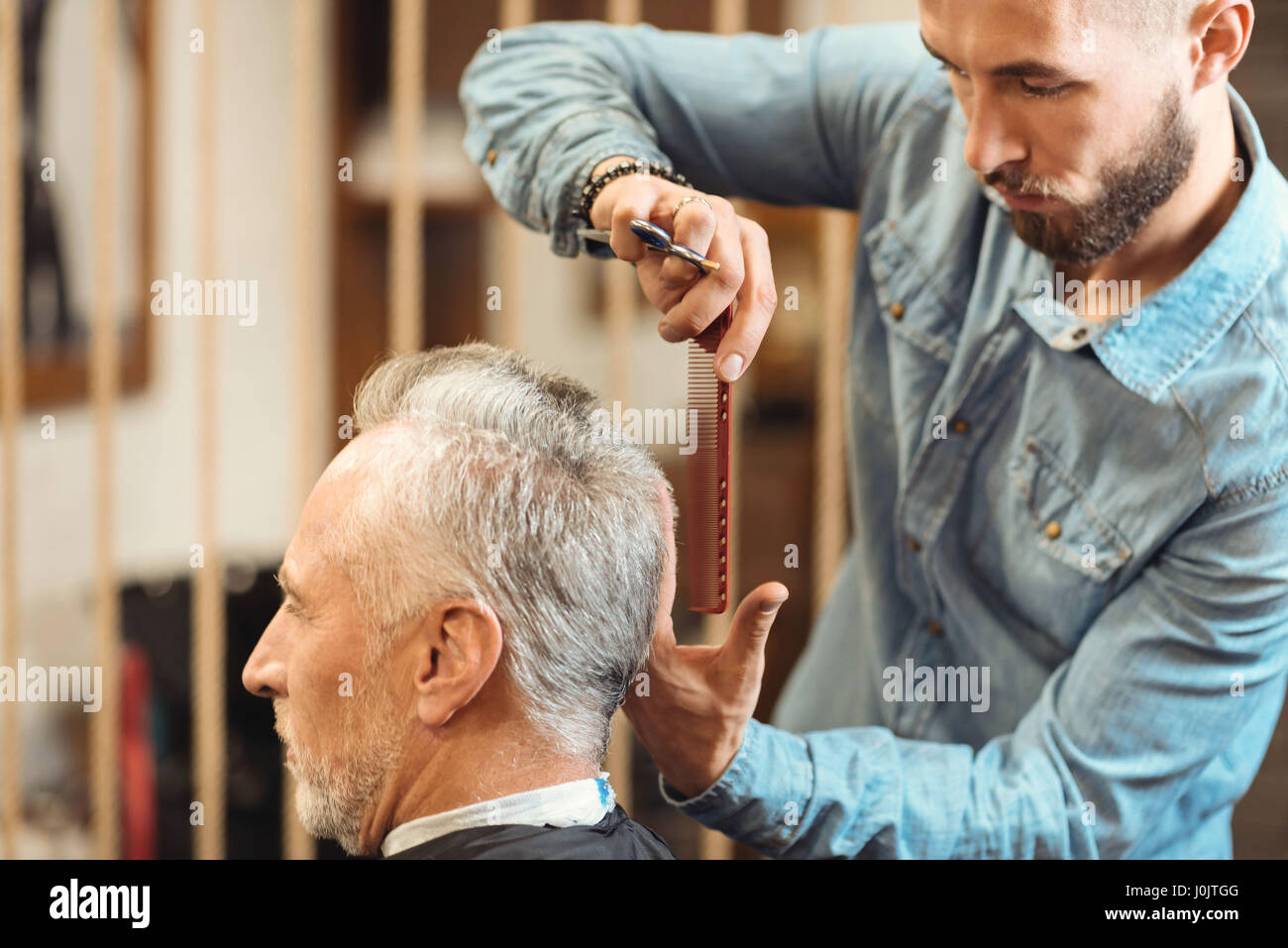 Young master creating new haircut in the salon Stock Photo - Alamy