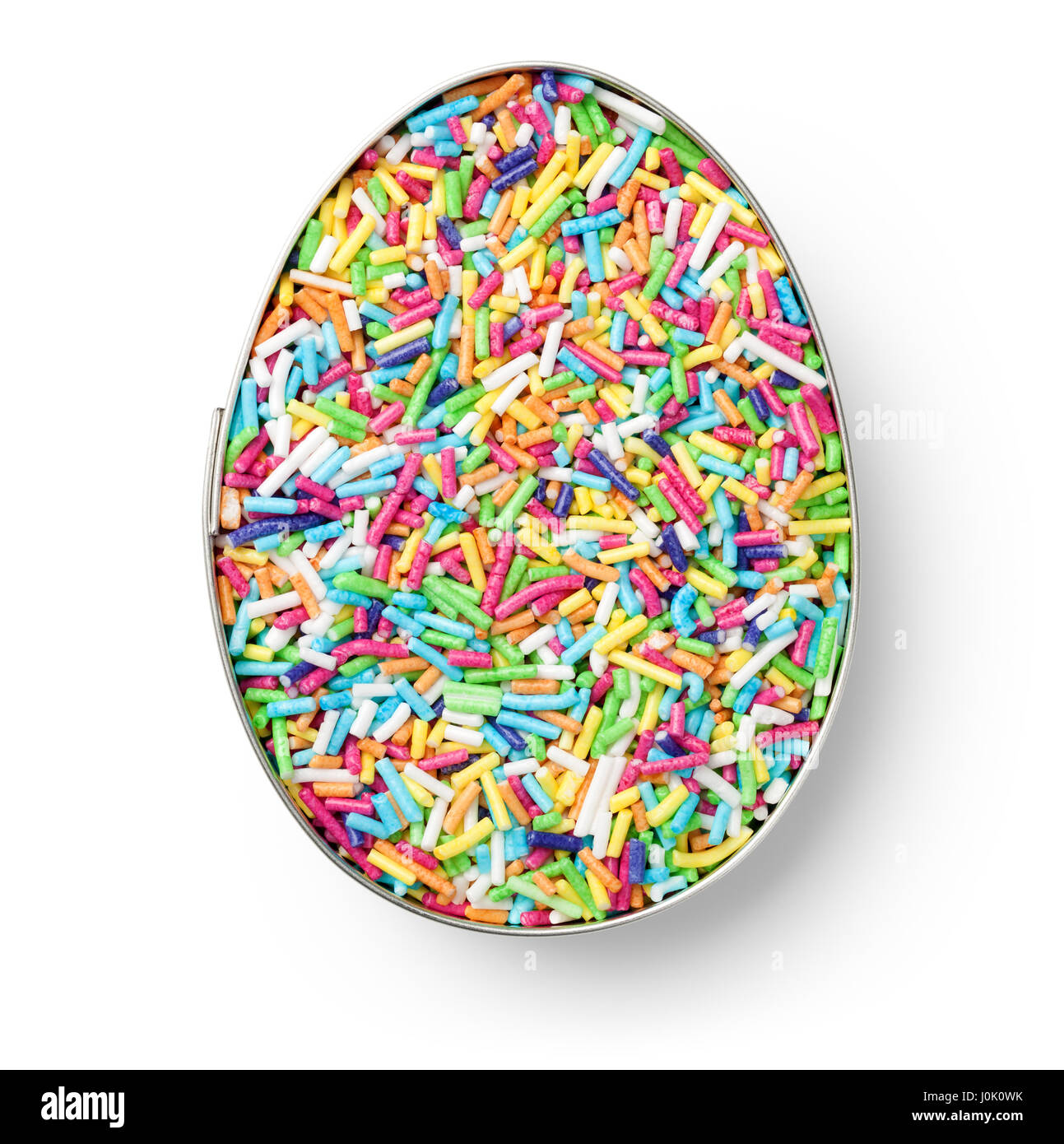 Colorful candy sprinkles in cutter in shape of egg on white background ...